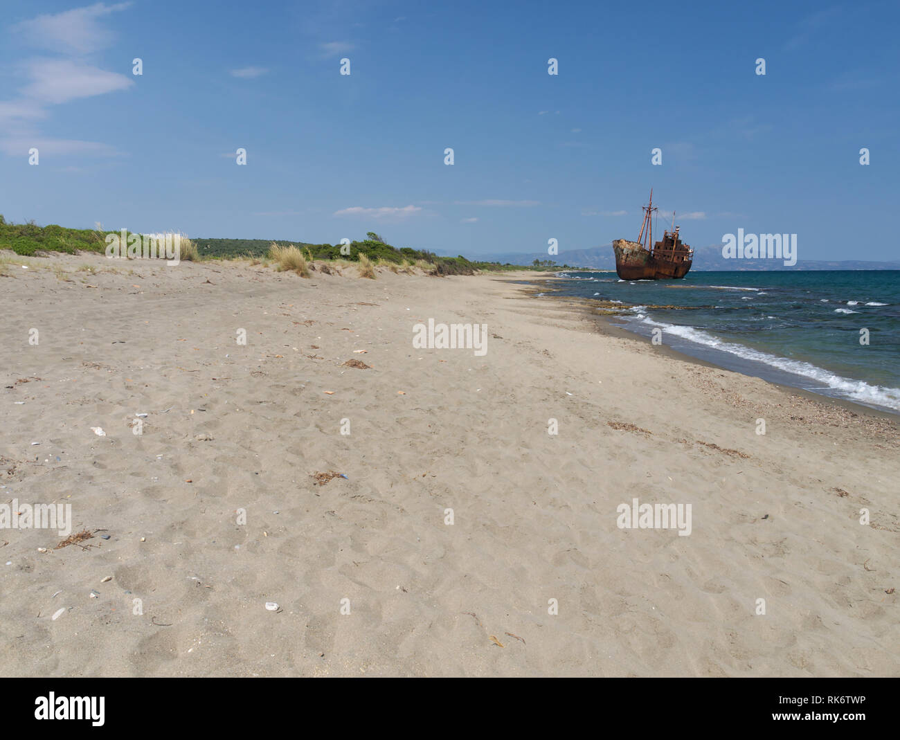 Rusty big ship shipwreck on Selinitsa beach under a deep blue sky at ...