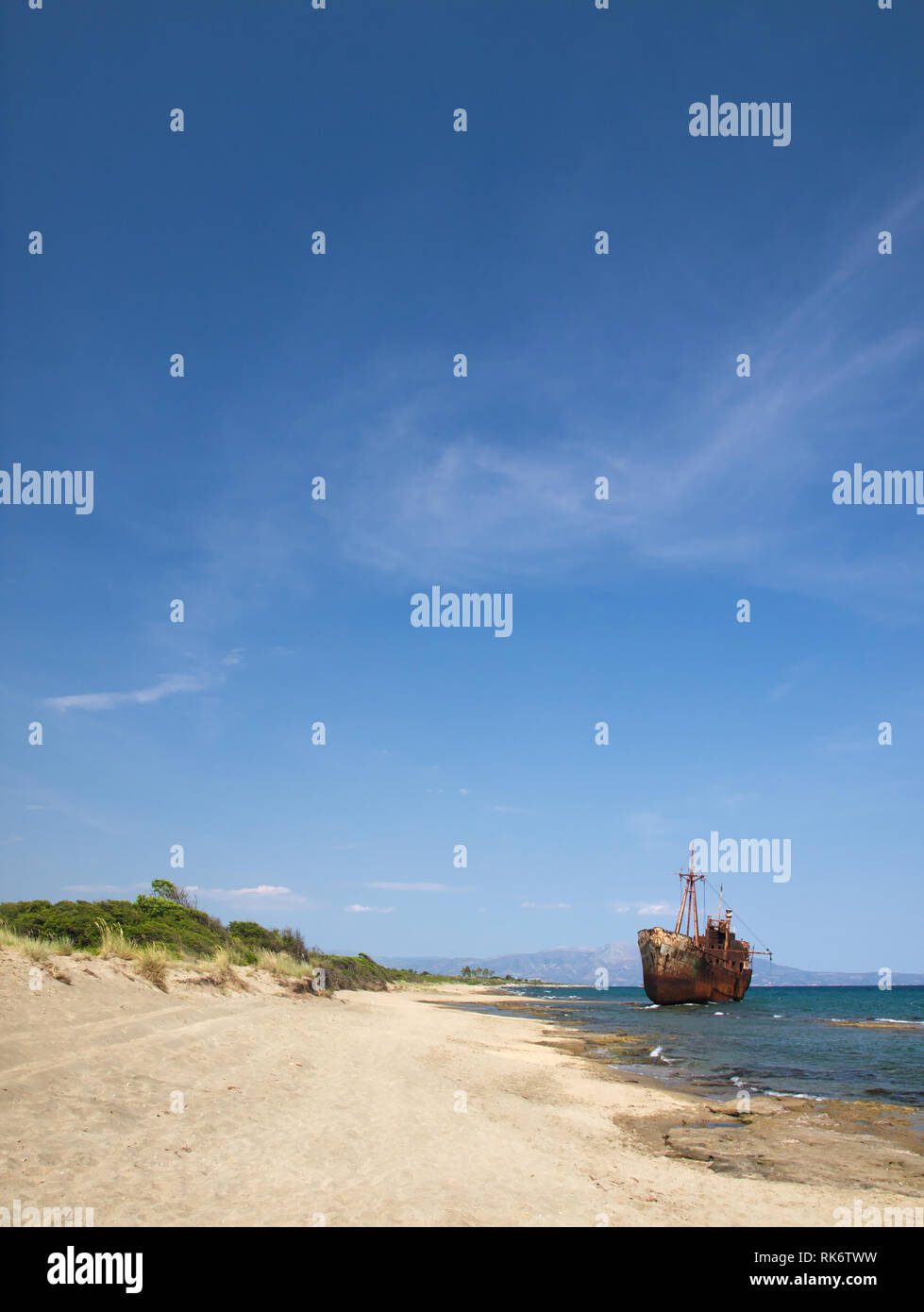 Rusty big ship shipwreck on Selinitsa beach under a deep blue sky at ...