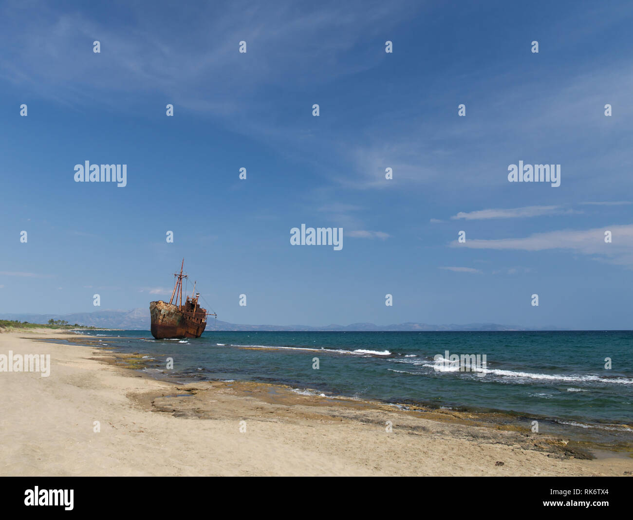 Rusty big ship shipwreck on Selinitsa beach under a deep blue sky at ...