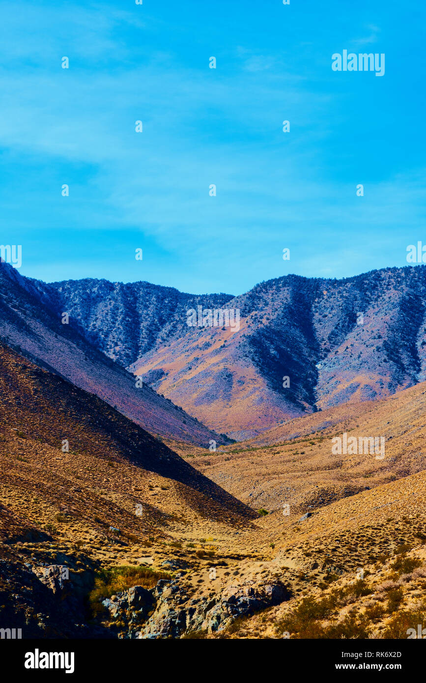 Autumn in the mountains of the Mojave Desert under bright blue sky. Two ...