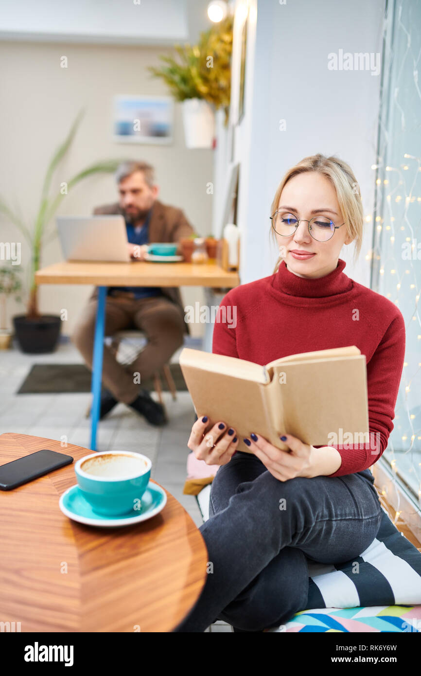 Woman reading in cafe Stock Photo - Alamy