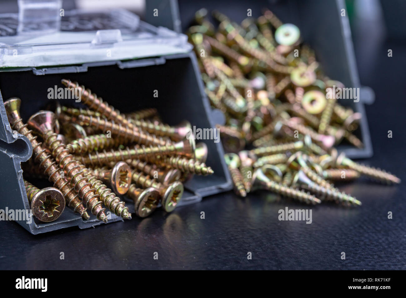 Screws in a box and a screwdriver on a workshop table. Accessories for ...