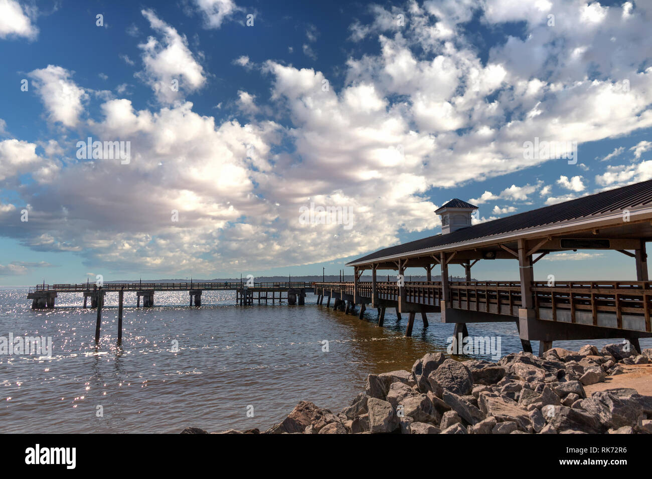 An old fishing pier on St Simons Island beyond rock seawall Stock Photo ...