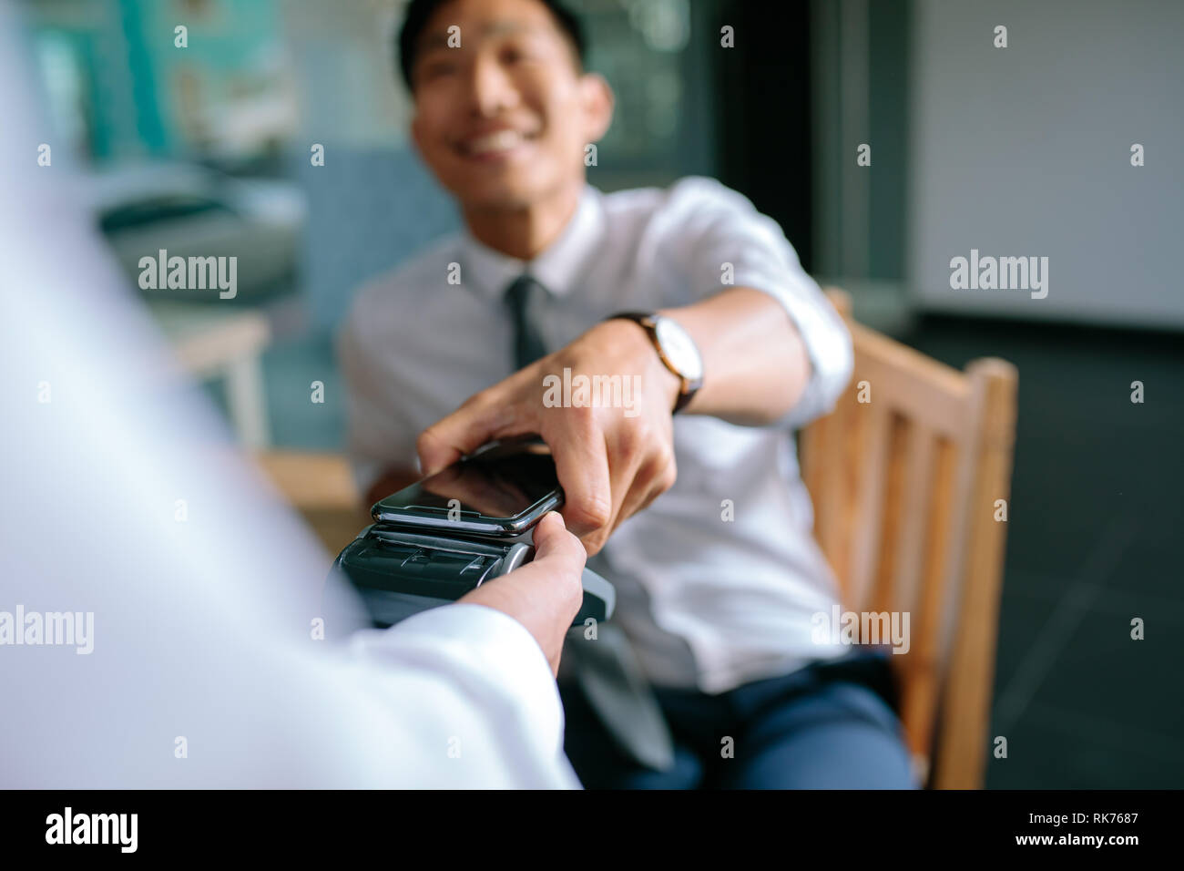 businessman paying bill through smartphone using NFC technology in ...