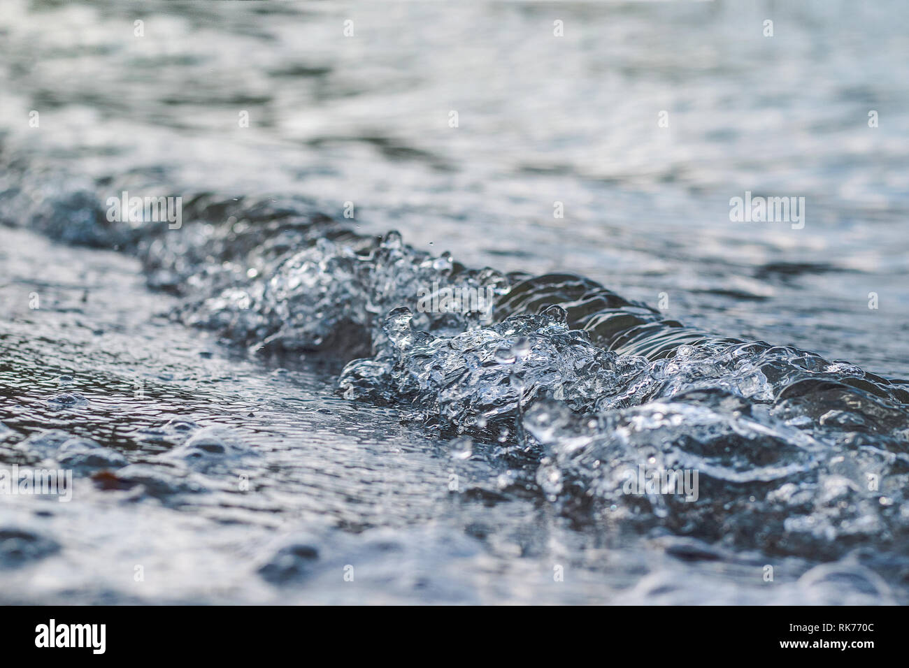 Water waves on a crystal clear lake at winter morning Stock Photo - Alamy