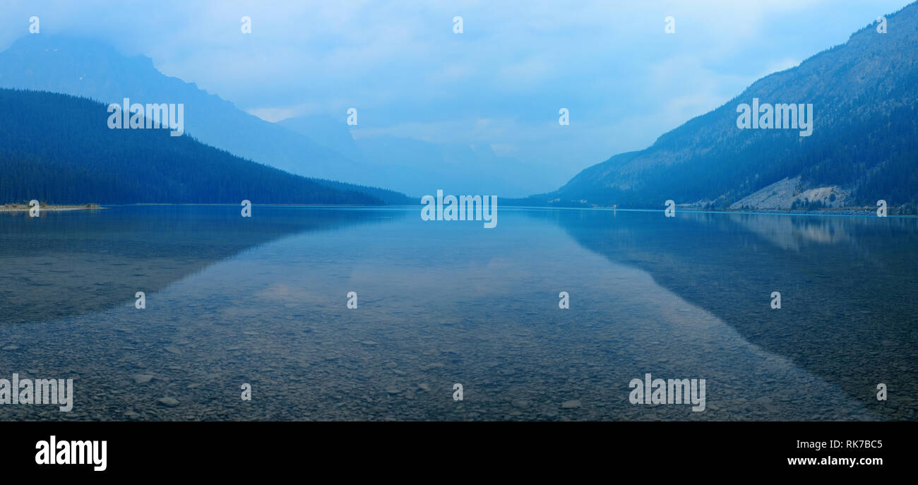 Lake at dusk with reflections and mountains in Banff National Park ...