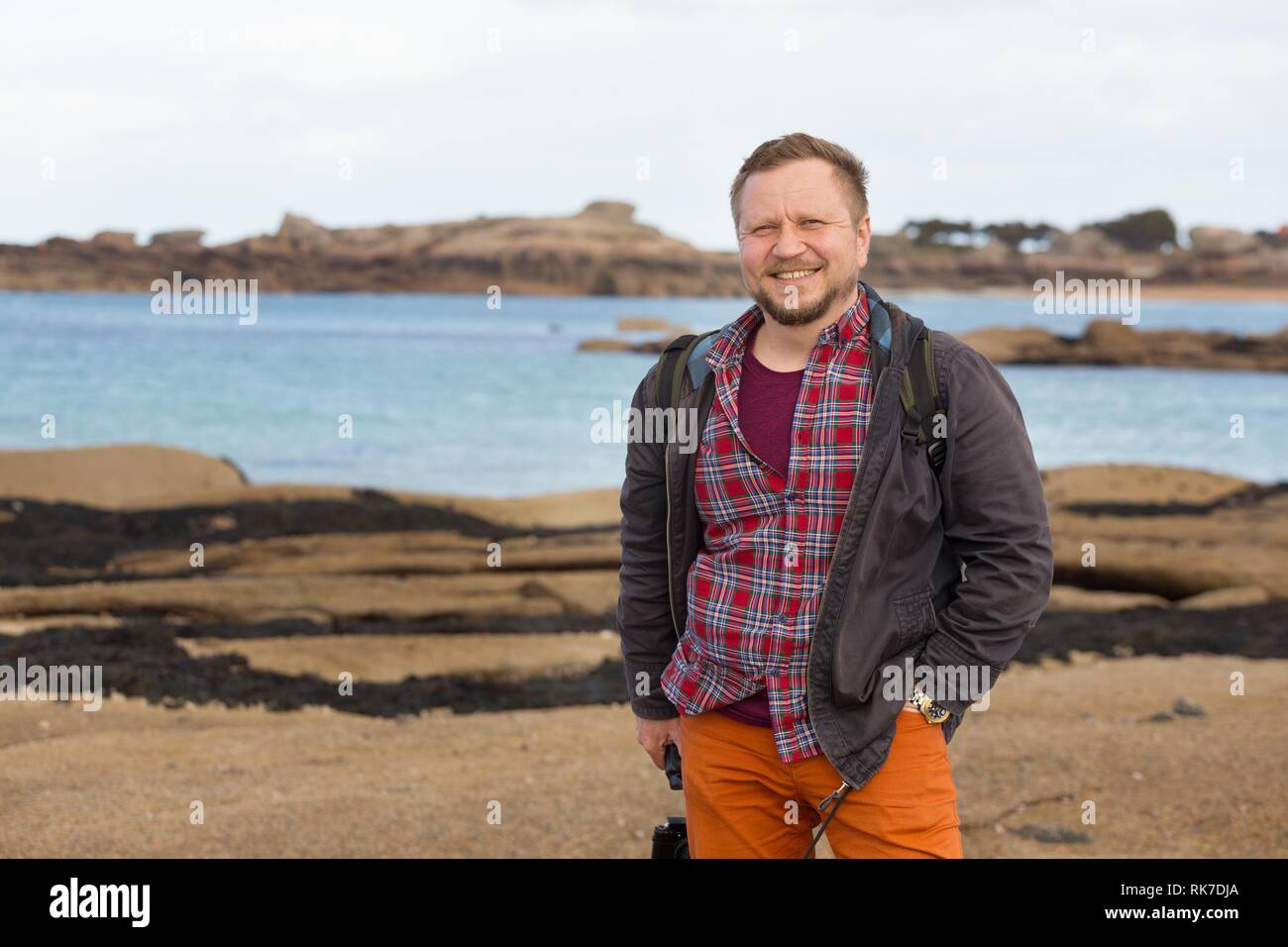 happy man walking on the shore of the sea at the Tregastel, normandy ...