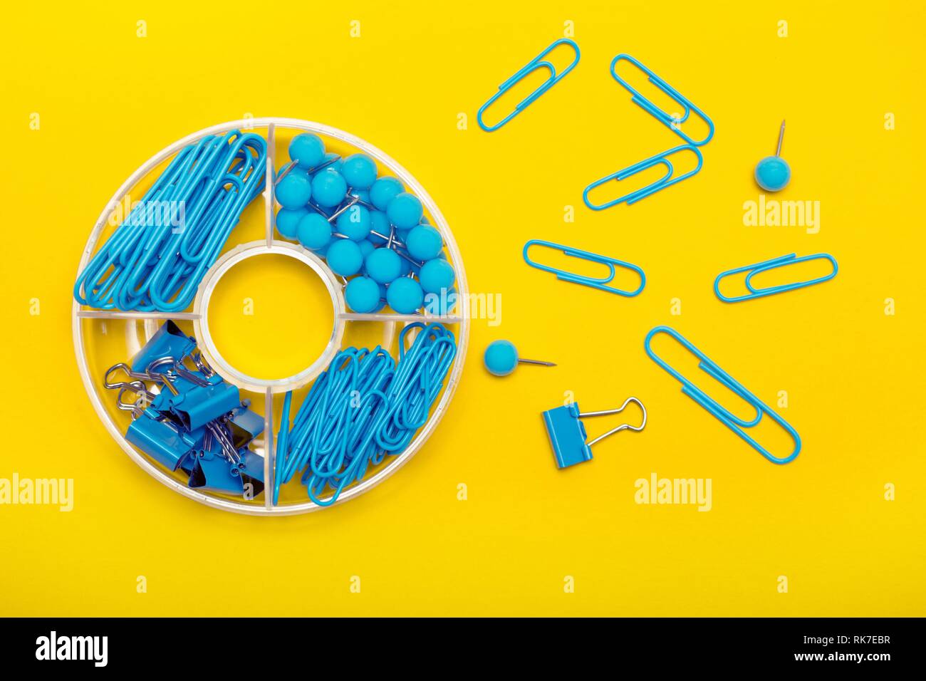 stationery paper clips, binders and buttons in blue on yellow ...