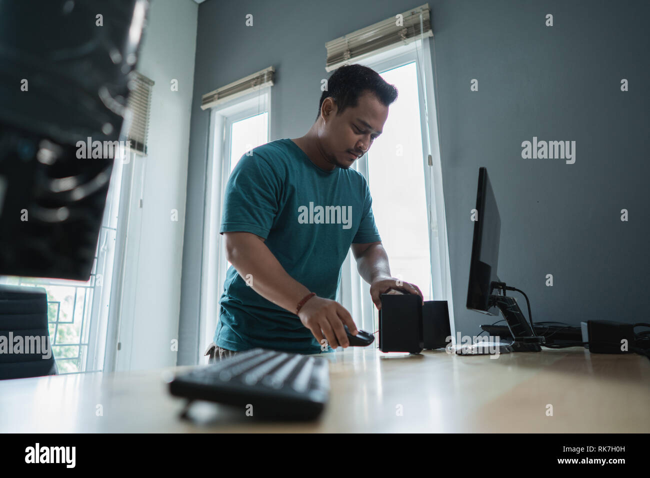 portrait of asian young man fix a problem of personal computer in ...