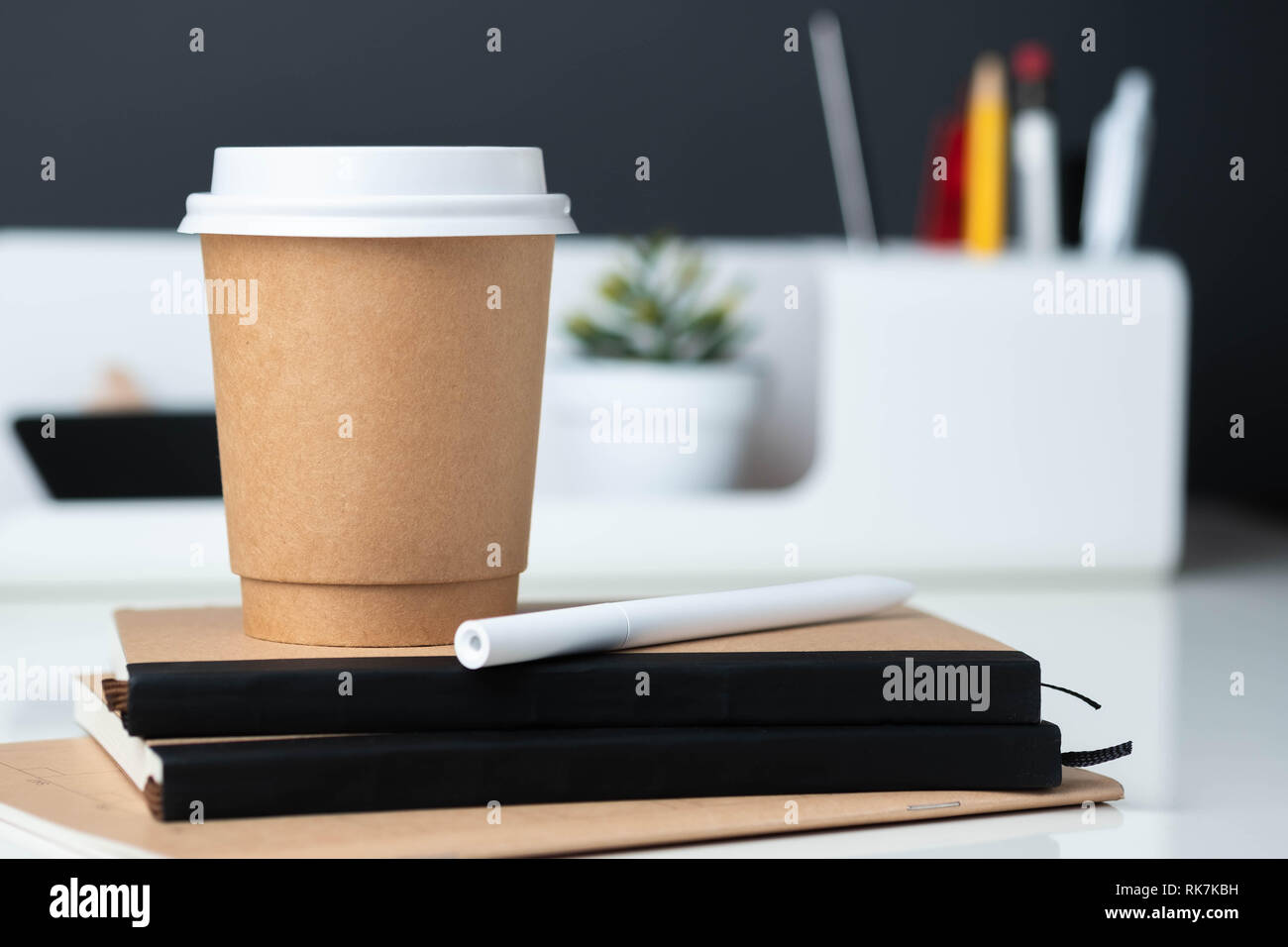 Coffee cup on notebook at modern office stationery on white table and ...