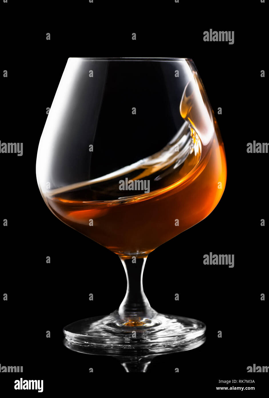 splash of cognac in snifter glass isolated on black background Stock ...