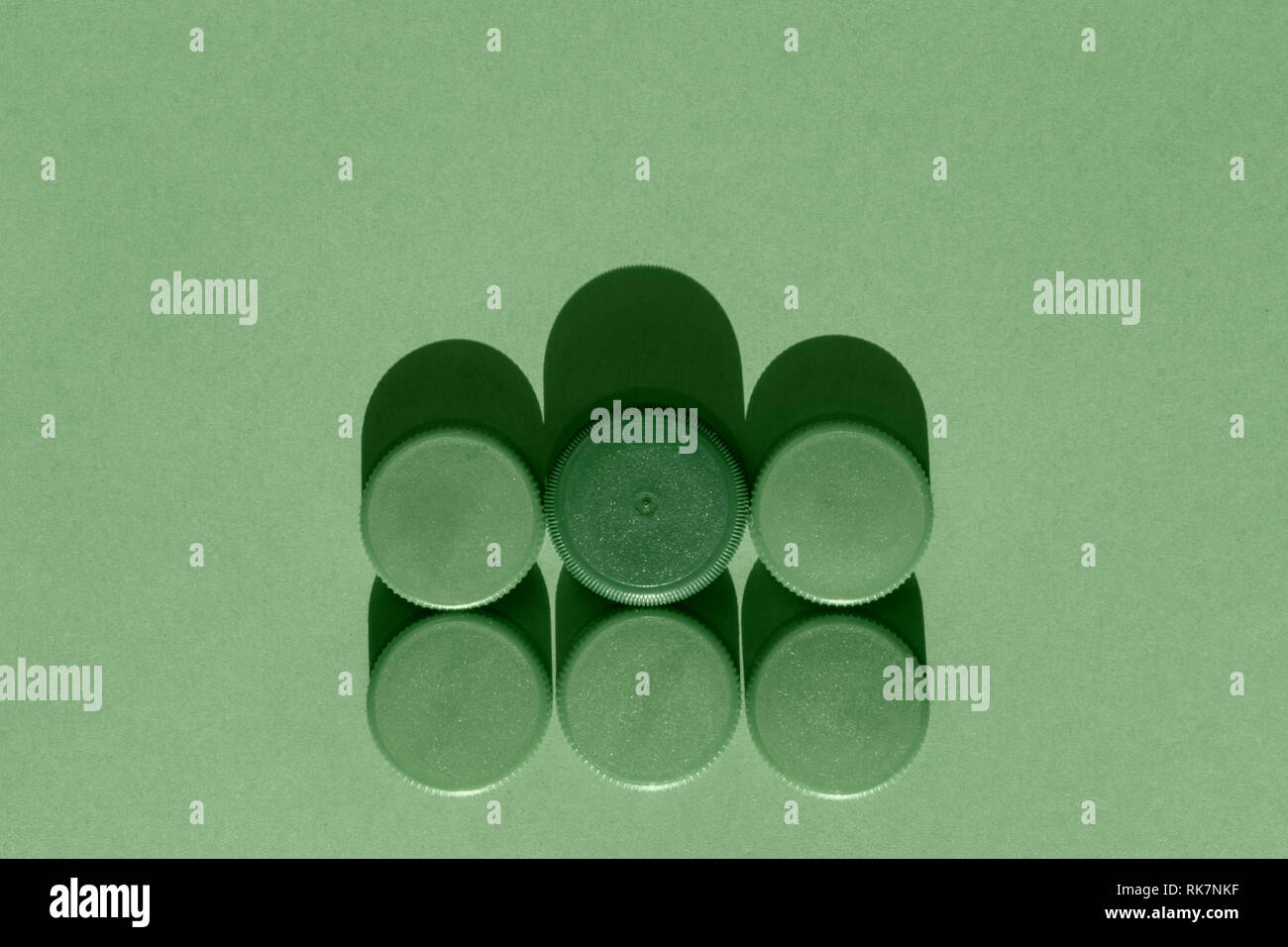Six green plastic bottle caps on a green background, the round caps are ...