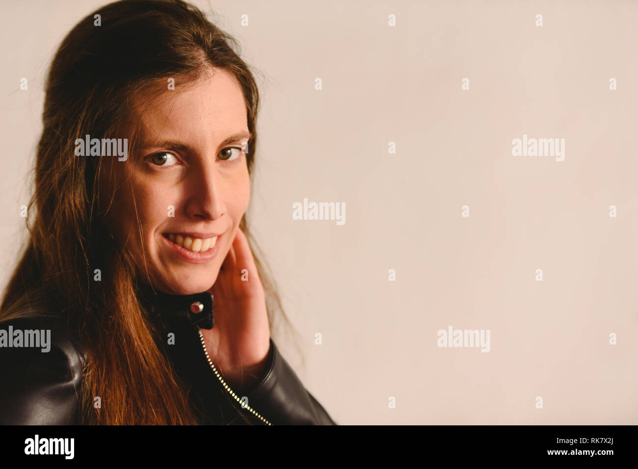 Young millennial woman standing in profile on white and red wall ...