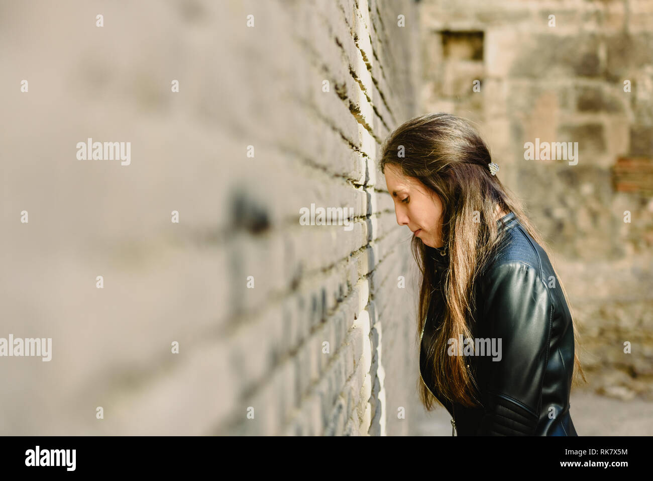 Desperate and sad woman face to the wall to find herself tired of ...