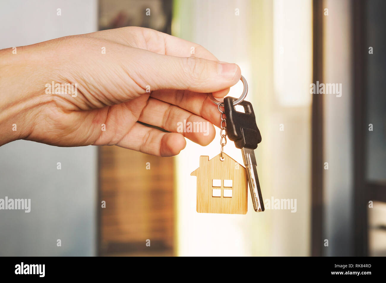 House key in male hand at apartment background. house key ring. Concept ...