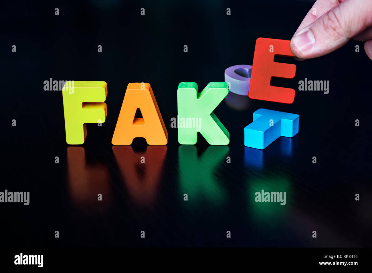Many-colored letters forming word FAKE instead of FACT on black ...