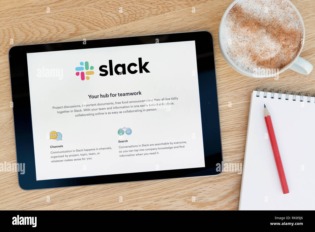 The Slack website features on an iPad tablet device which rests on a ...