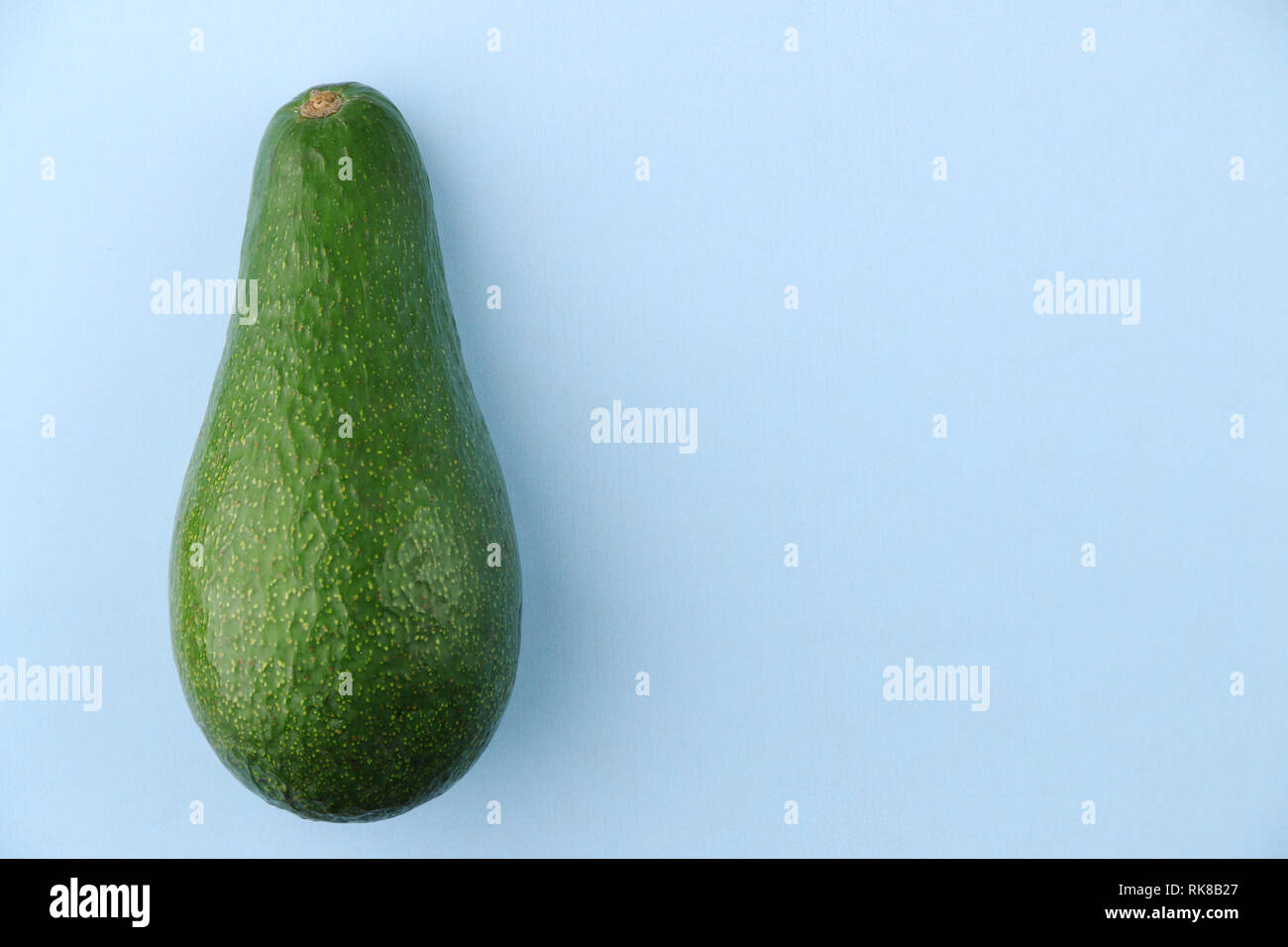 whole avocado on a light blue back Stock Photo - Alamy