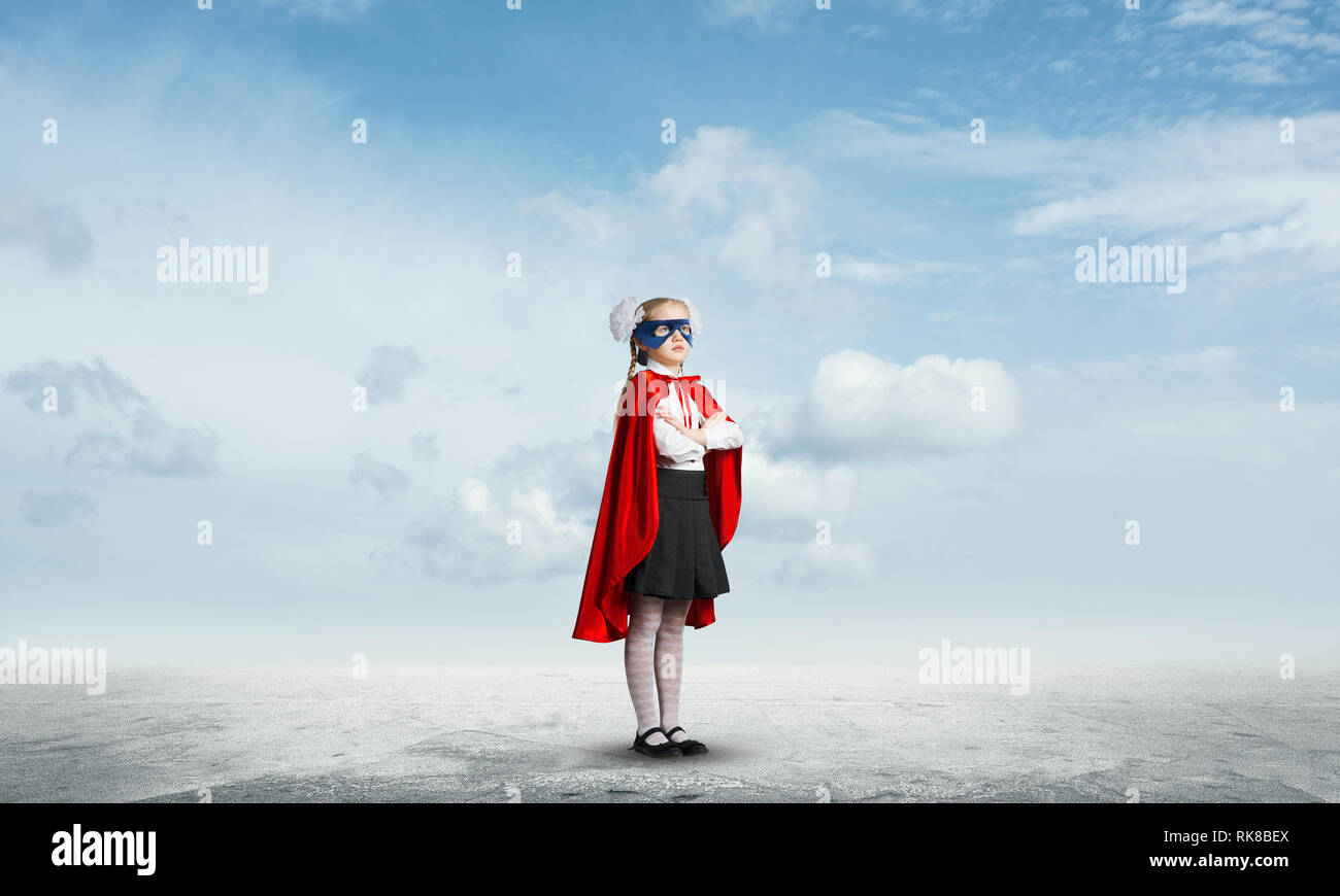 Girl power concept with cute kid guardian against cloudscape background ...