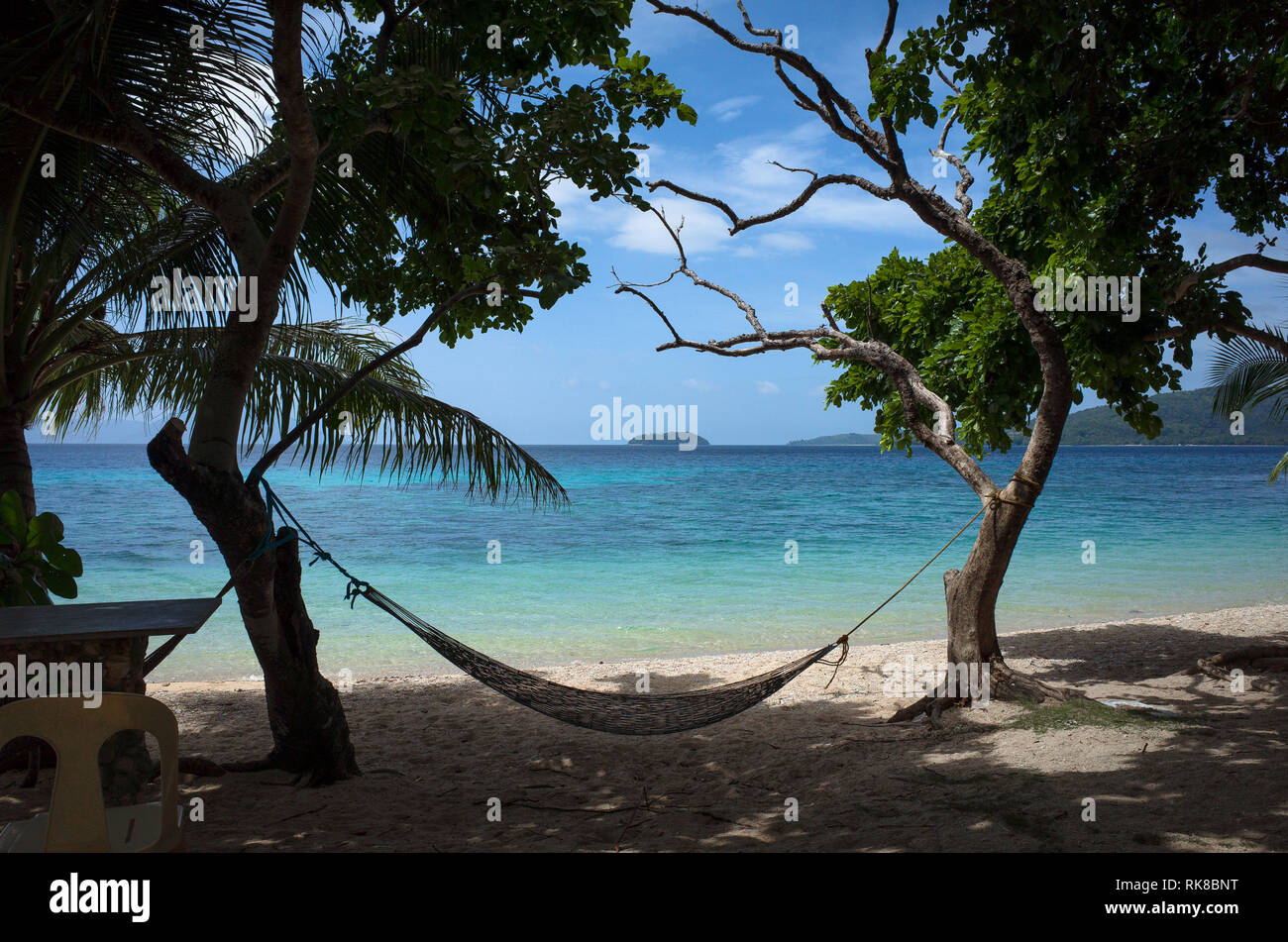 Rope hammock between trees on turquoise sea beach - Camiguin Island ...