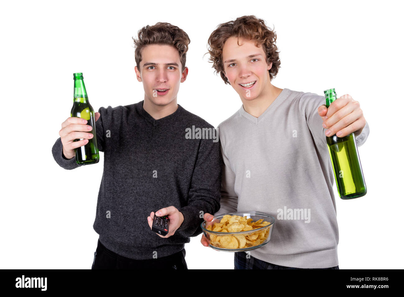 Two happy guys drinking beer and eating chips while watching football ...