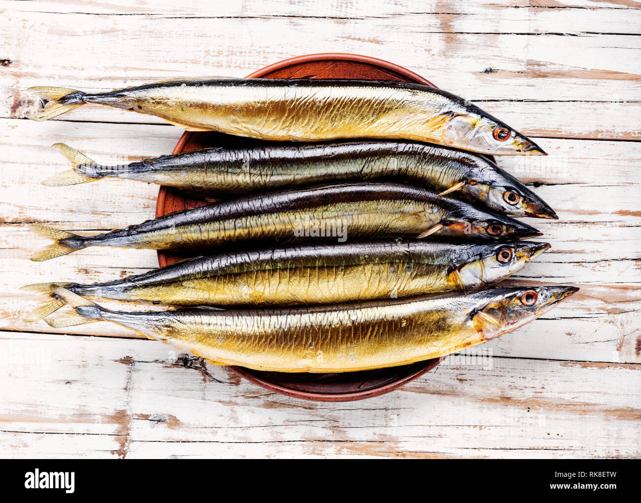 Smoked fish on kitchen board.Smoked saury.Fish food Stock Photo - Alamy