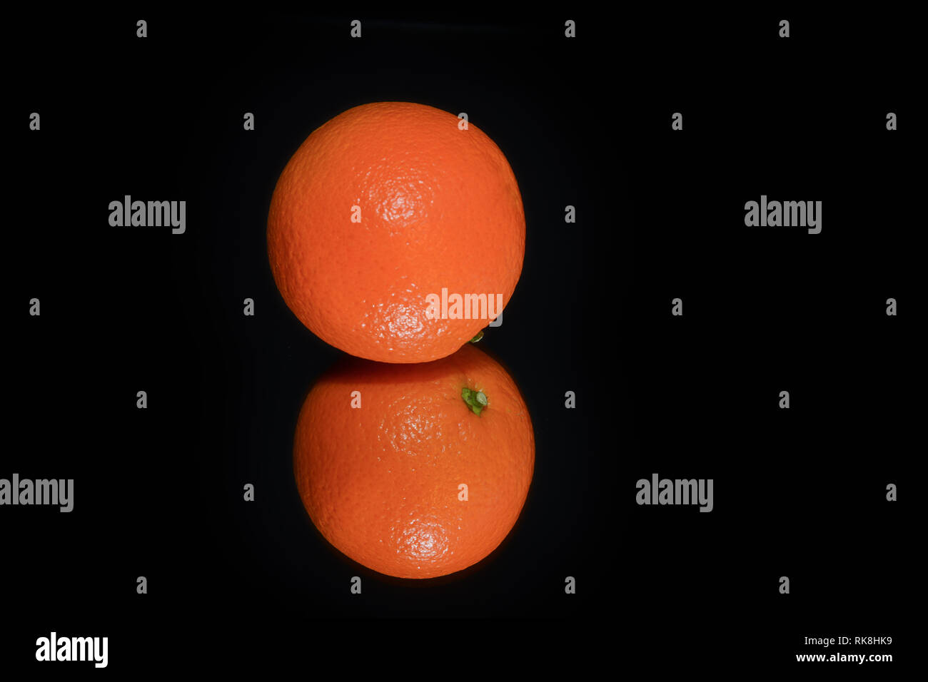 whole orange and reflection on mirror with a black background Stock ...