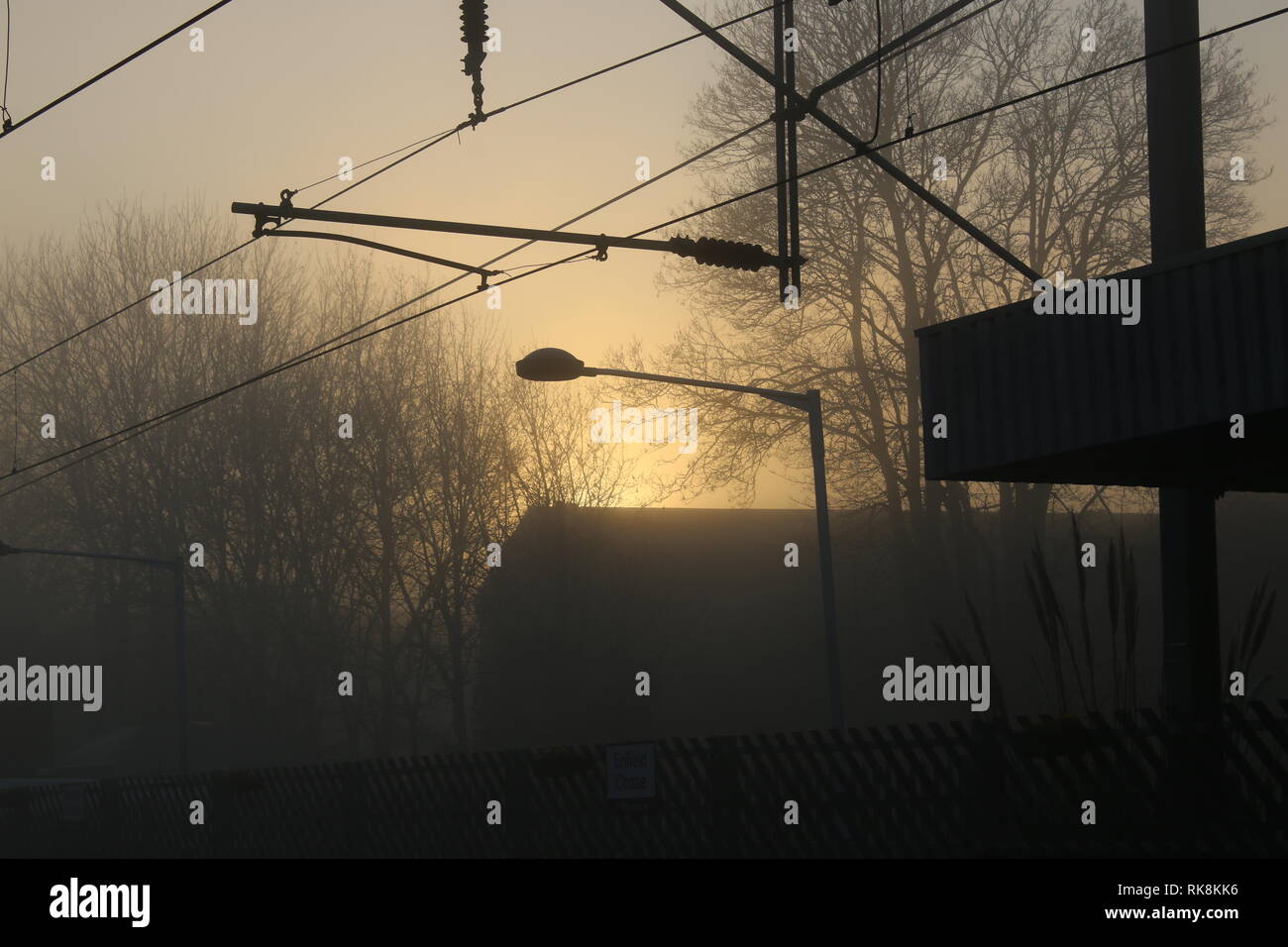Sunset through fog, trees and power lines at Enfield Chase train ...