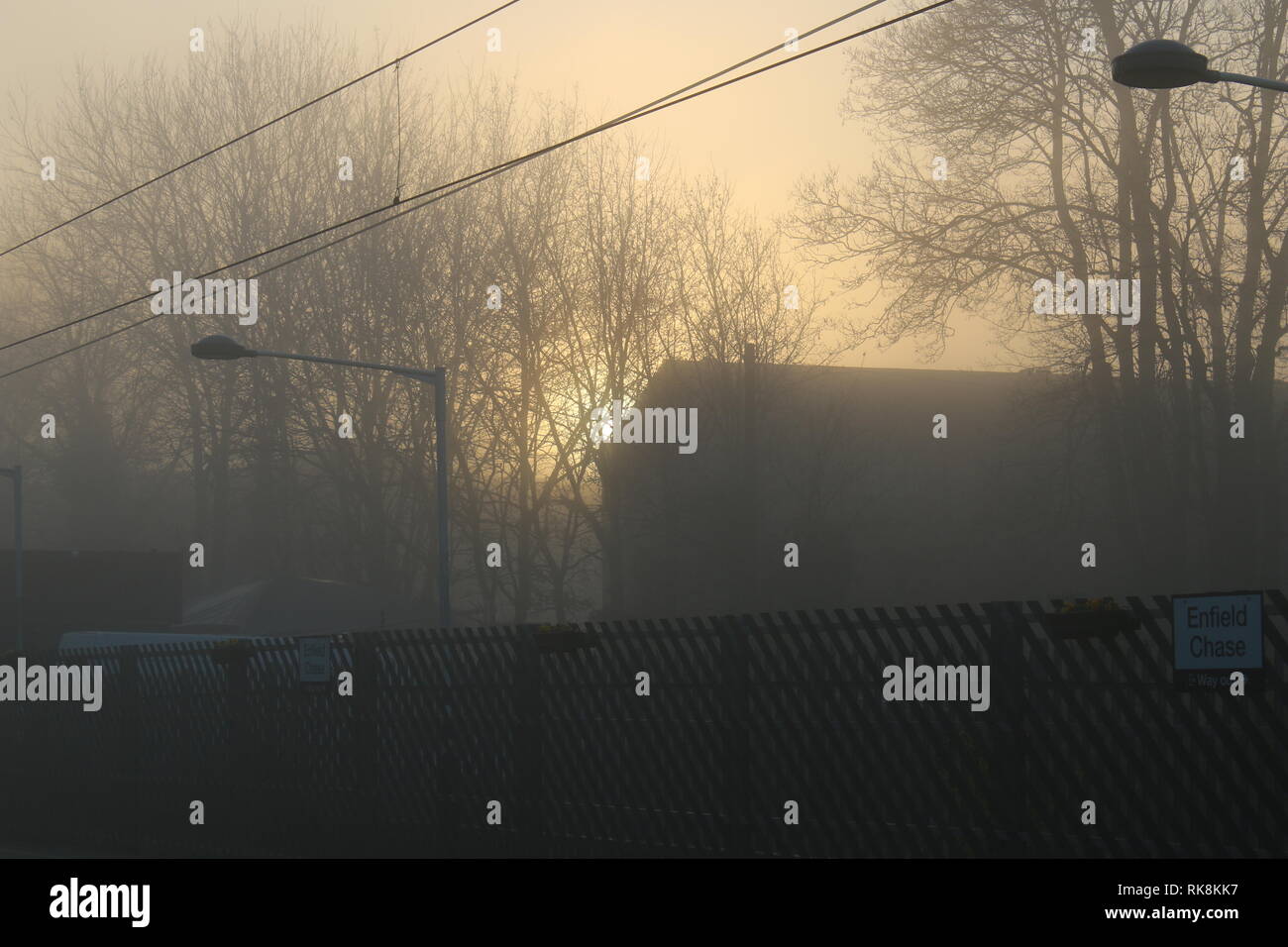 Sunset through fog, trees and power lines at Enfield Chase train ...