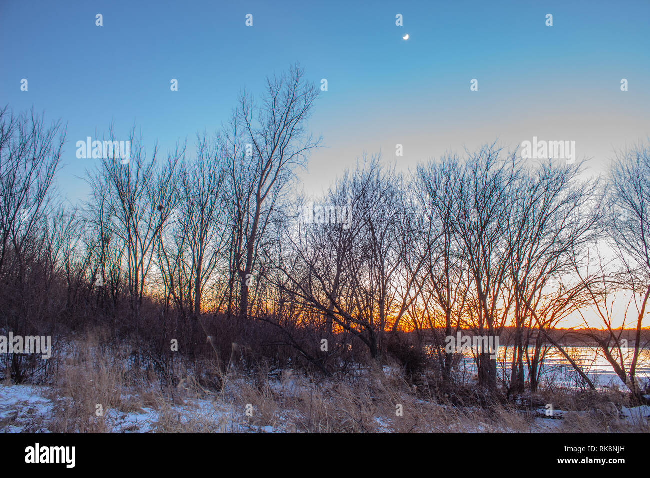 Sunset at a state park in Omaha Nebraska during winter with a lake and ...