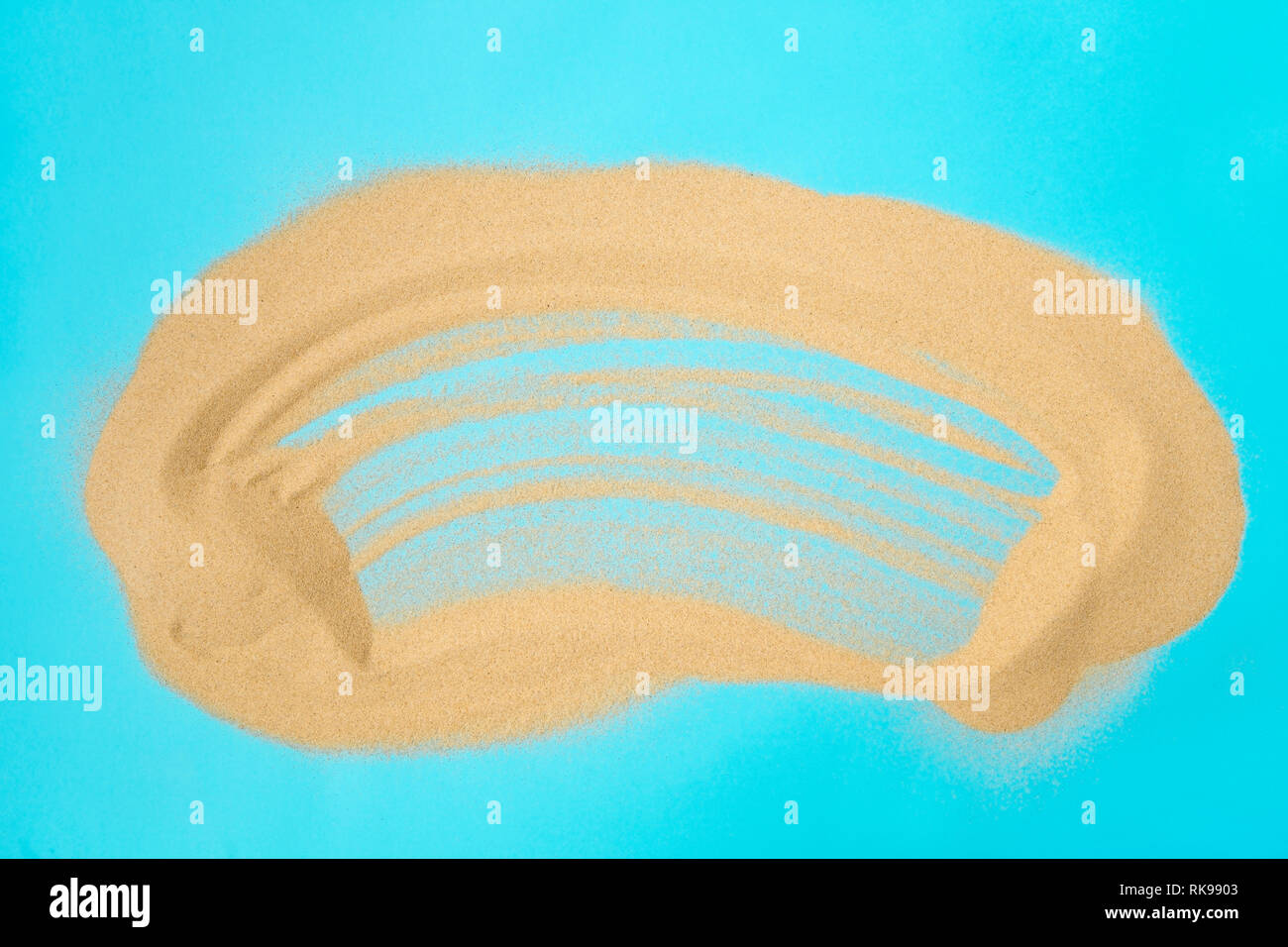 Sand heap on blue background Stock Photo - Alamy
