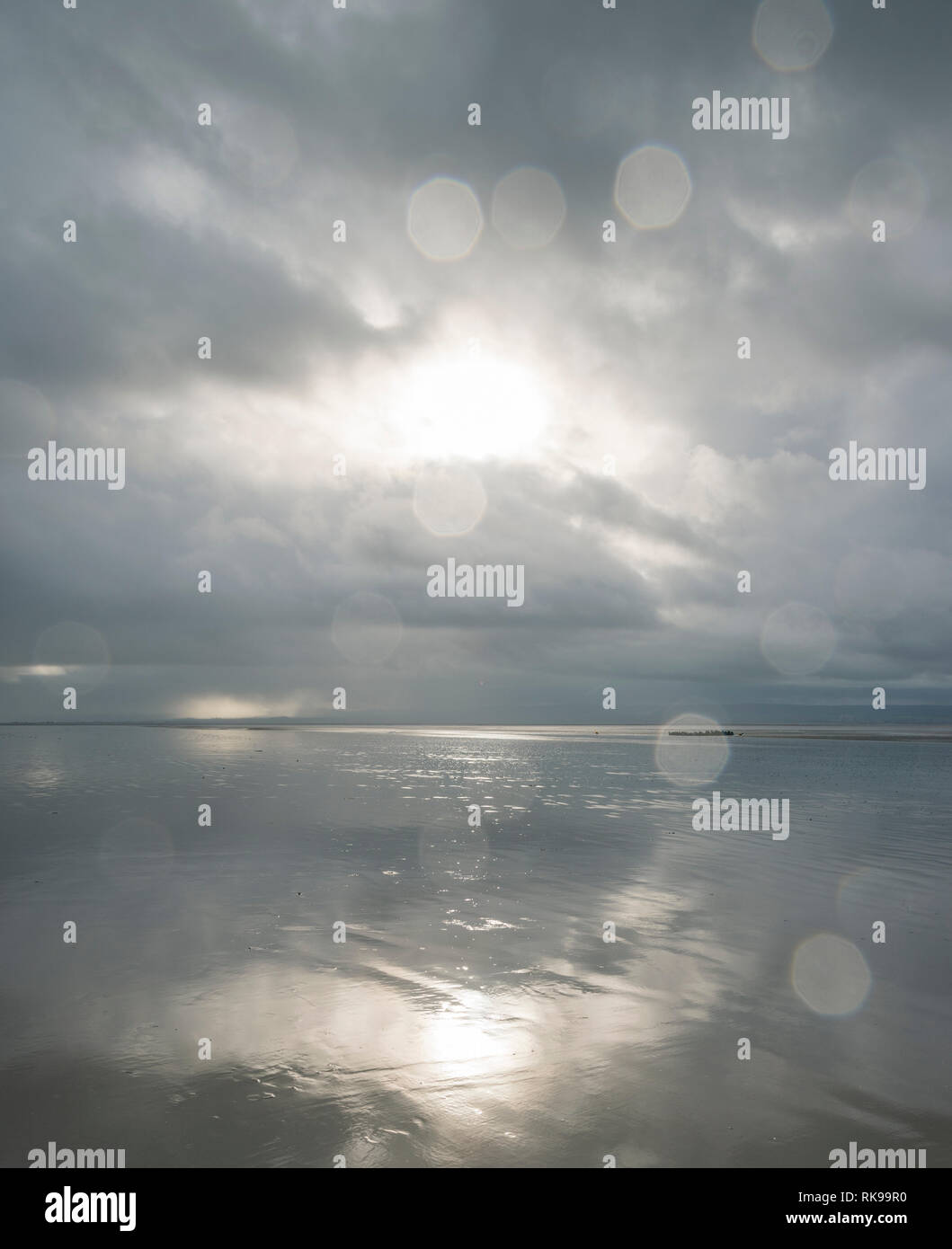 Raindrops on the lens cause flare during a rain storm at the beach ...