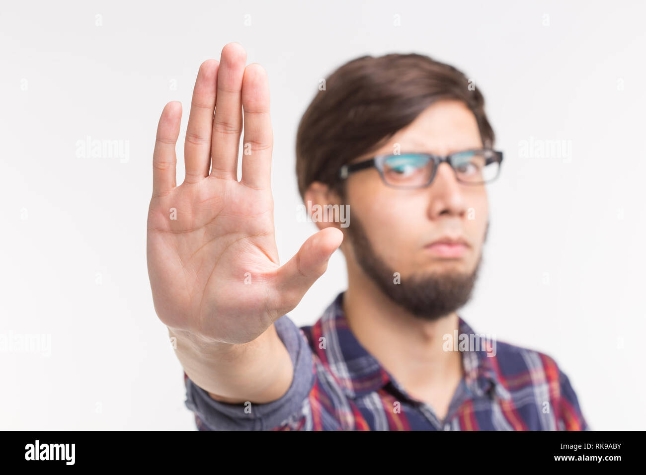 People, expression and gesture concept - young man showing stop gesture ...
