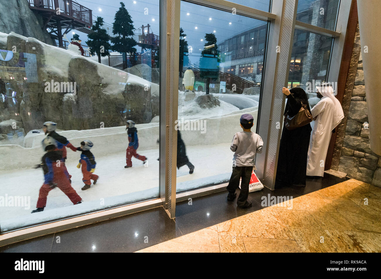 Visitors and families watching through large glass windows of skiers ...