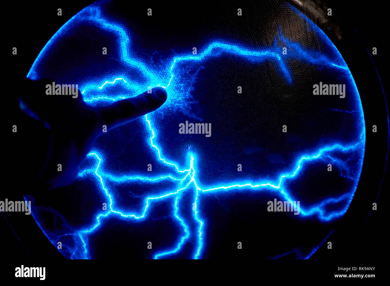 Finger touch electric plasma ball on dark background. Static ...