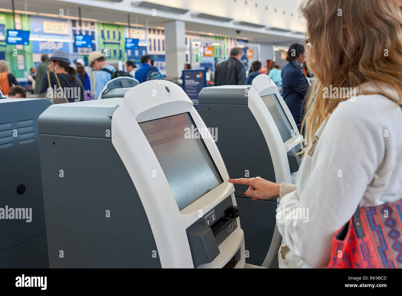 NEW YORK - MARCH 22, 2016: woman use check-in kiosk in JFK airport ...
