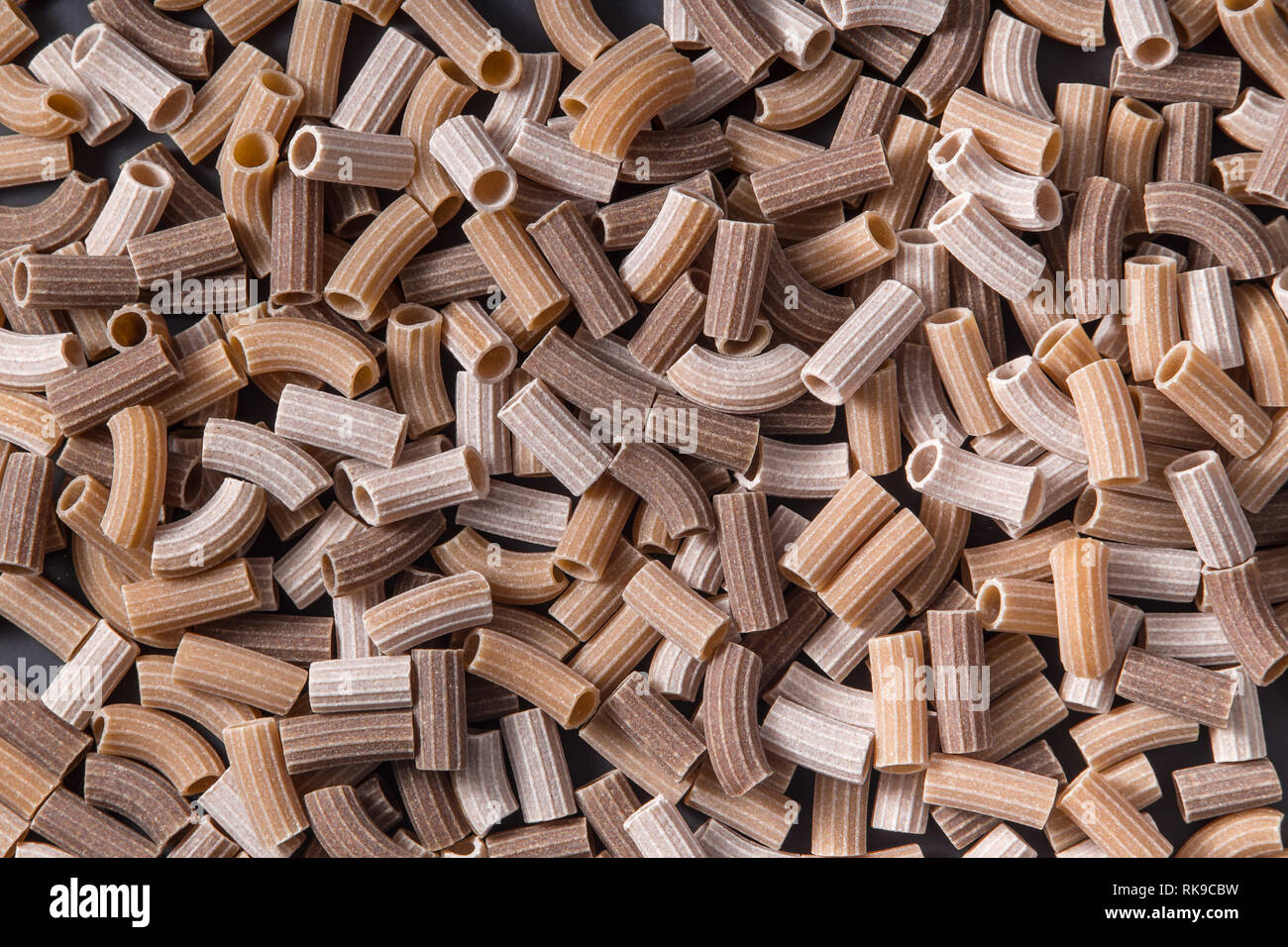 Italian raw colored whole wheat pasta on black background Stock Photo ...