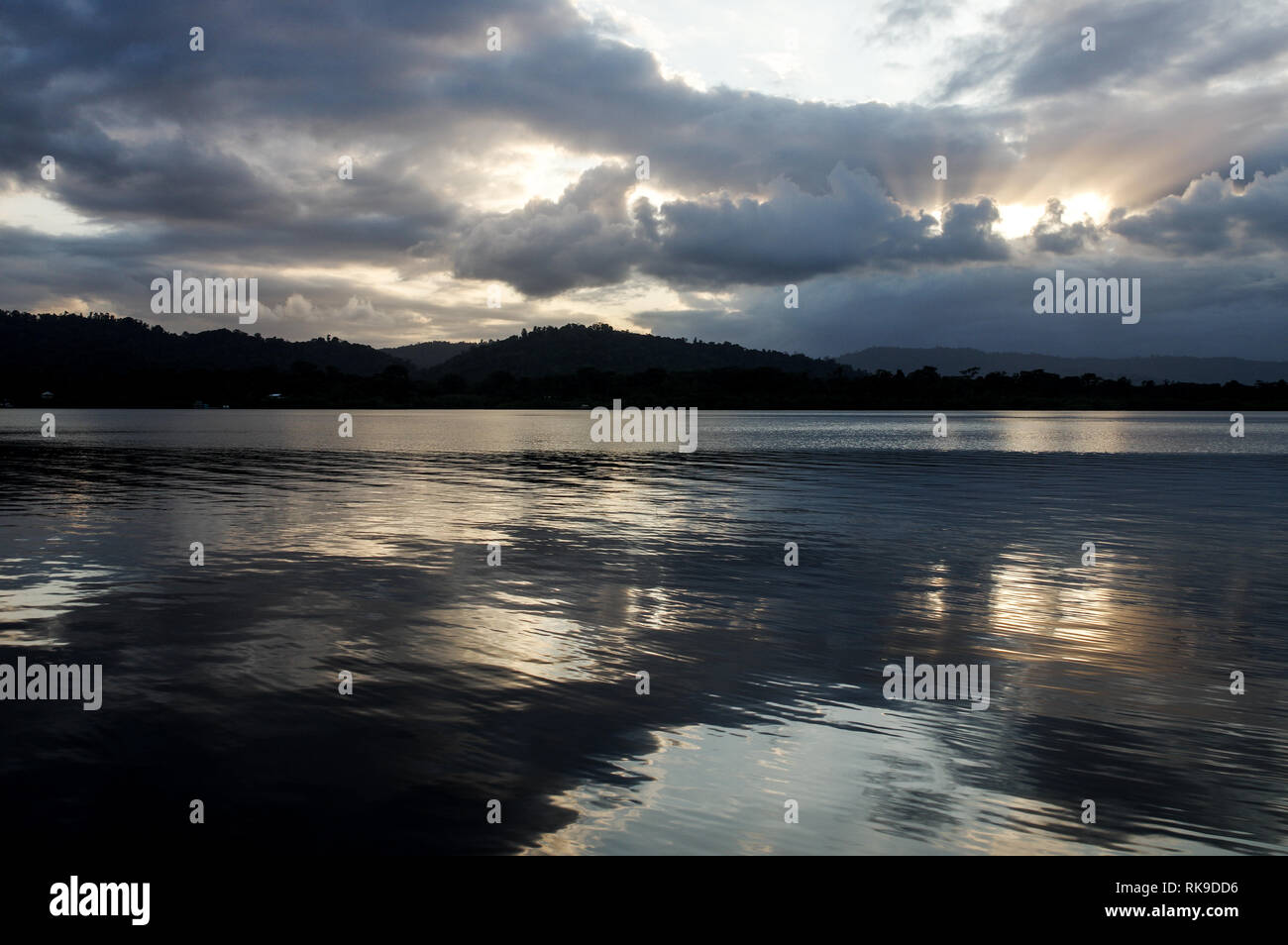 Setting sun shining through the thick cloud cover over Tierra Oscura ...