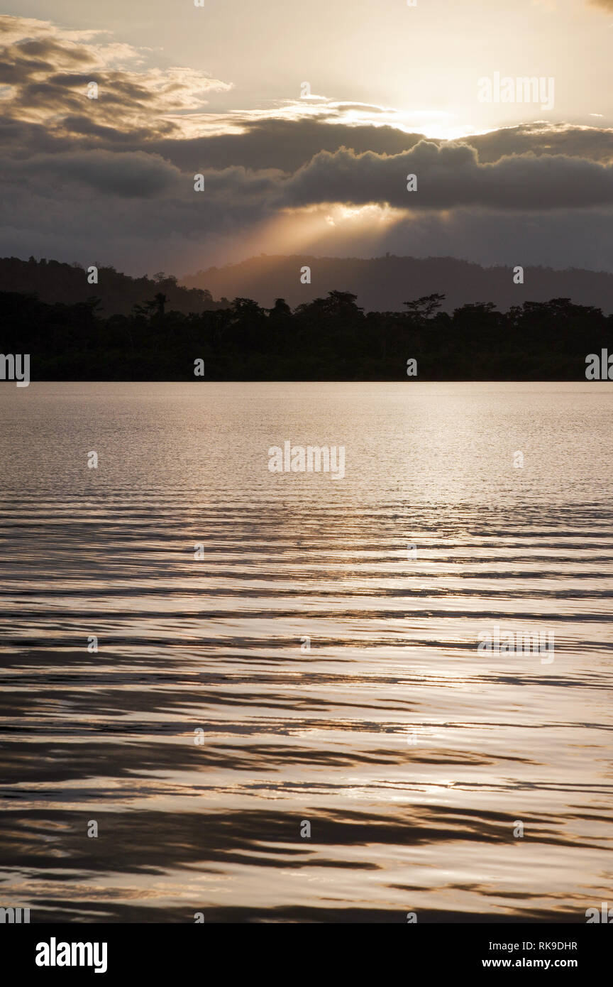 Setting sun shining through the thick cloud cover over Tierra Oscura ...