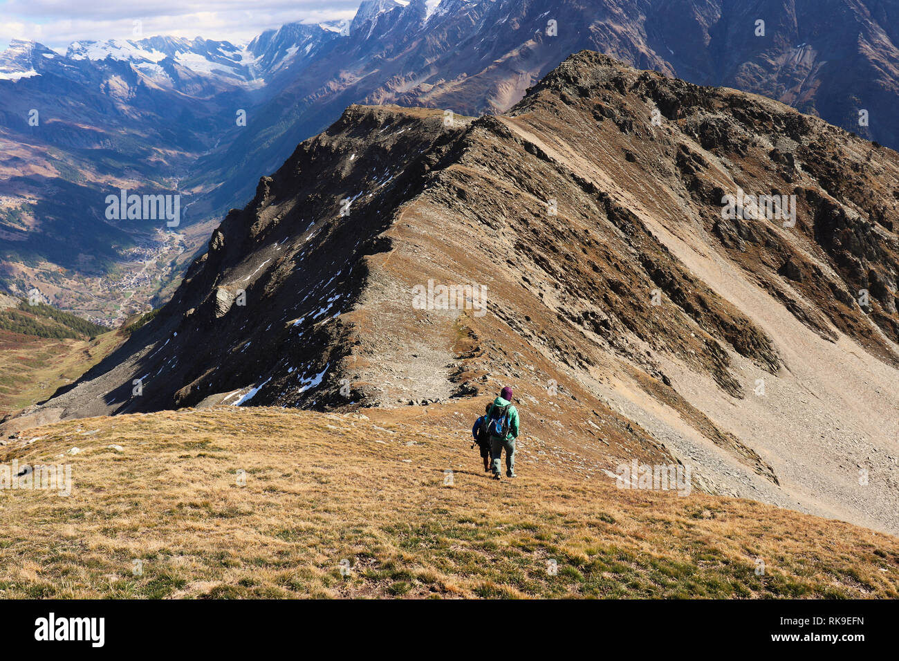 Hiker walking down mountain ridge Stock Photo - Alamy