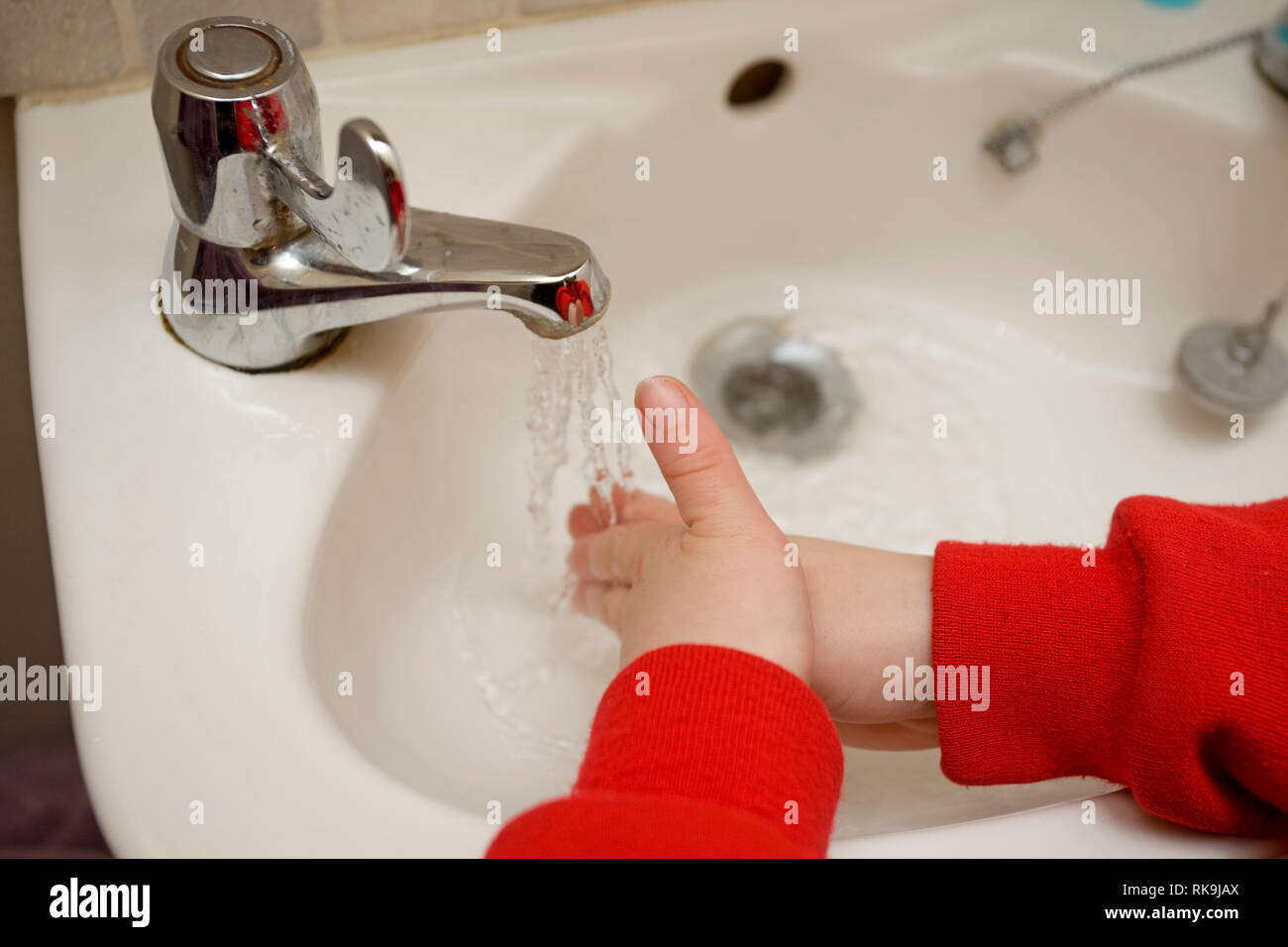 washing hands under hot tap Stock Photo - Alamy