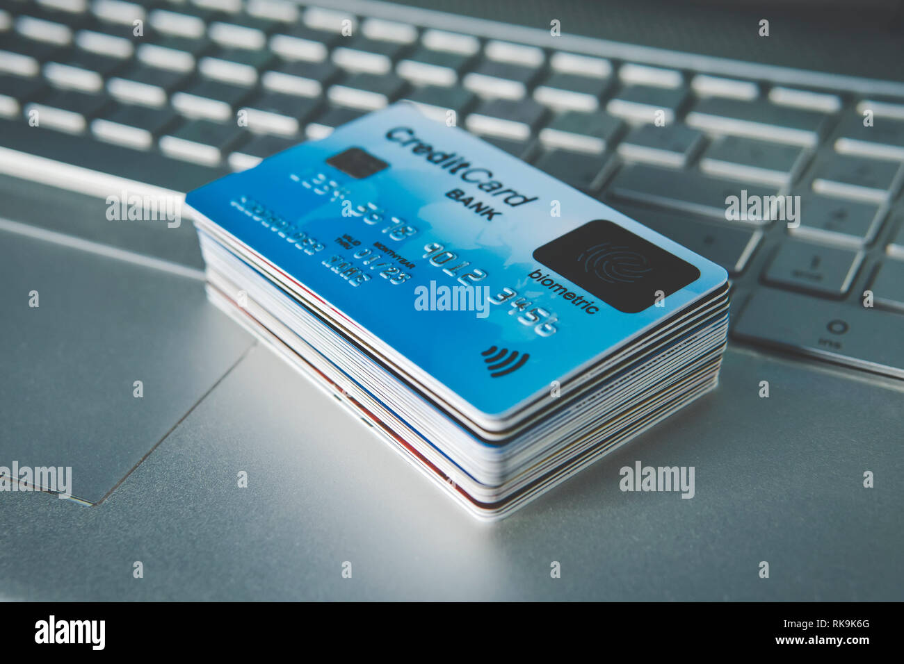 Close up of credit cards set in pile on laptop keyboard. E-commerce ...