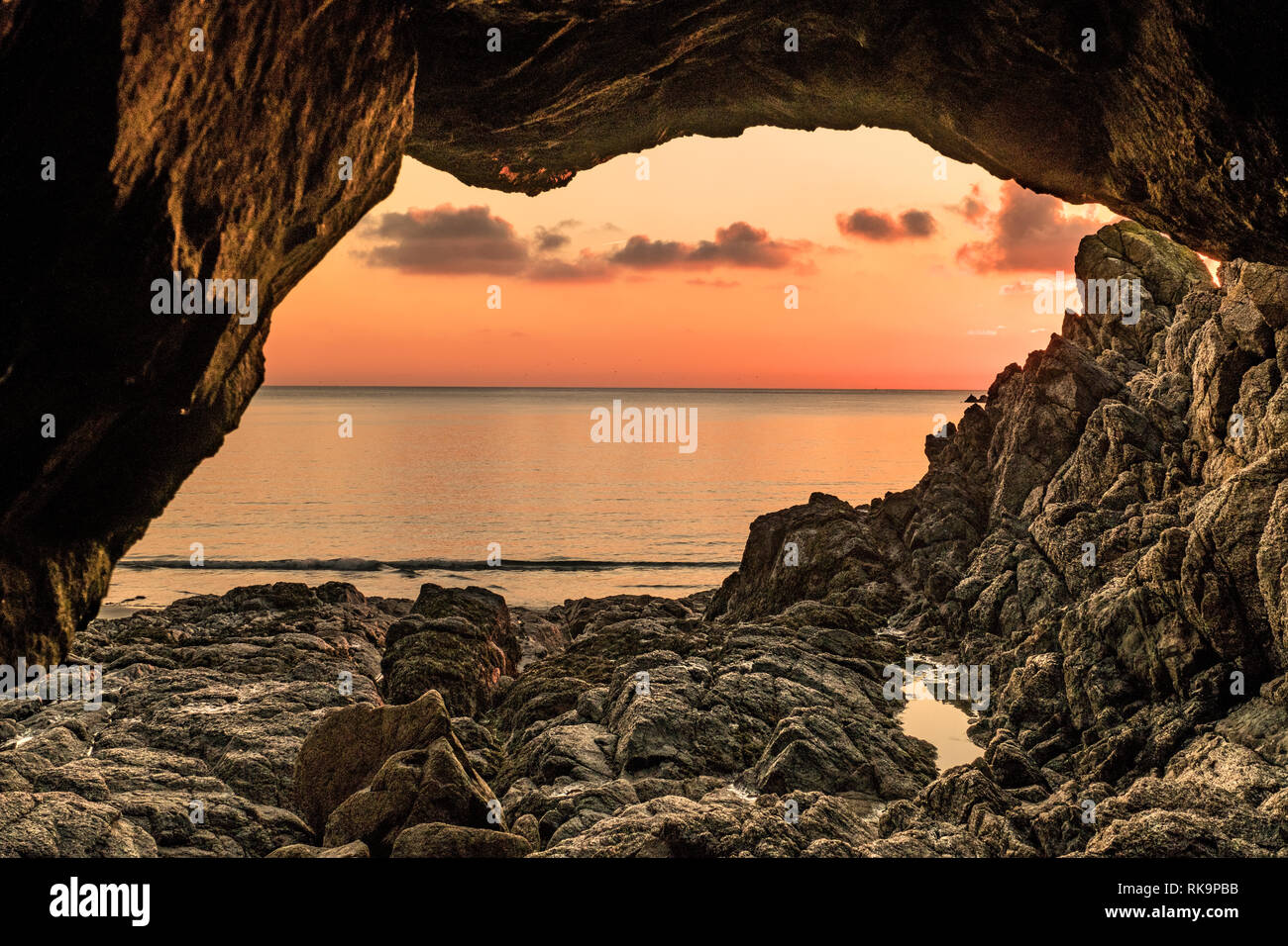 Sunset view from a cave at Petit Port on the south coast of Guernsey ...