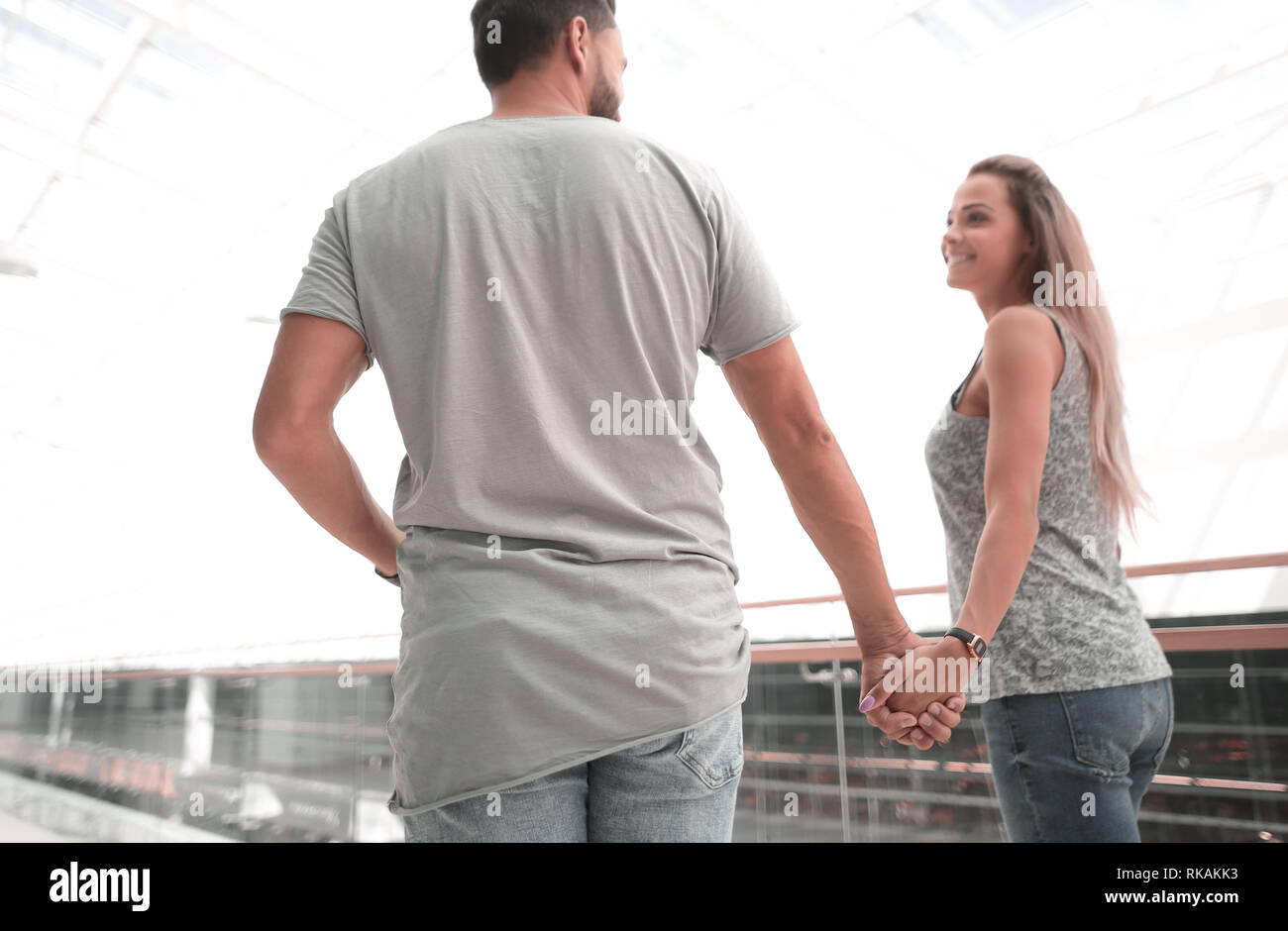 rear view.the young couple goes holding each other's hands.photo with ...