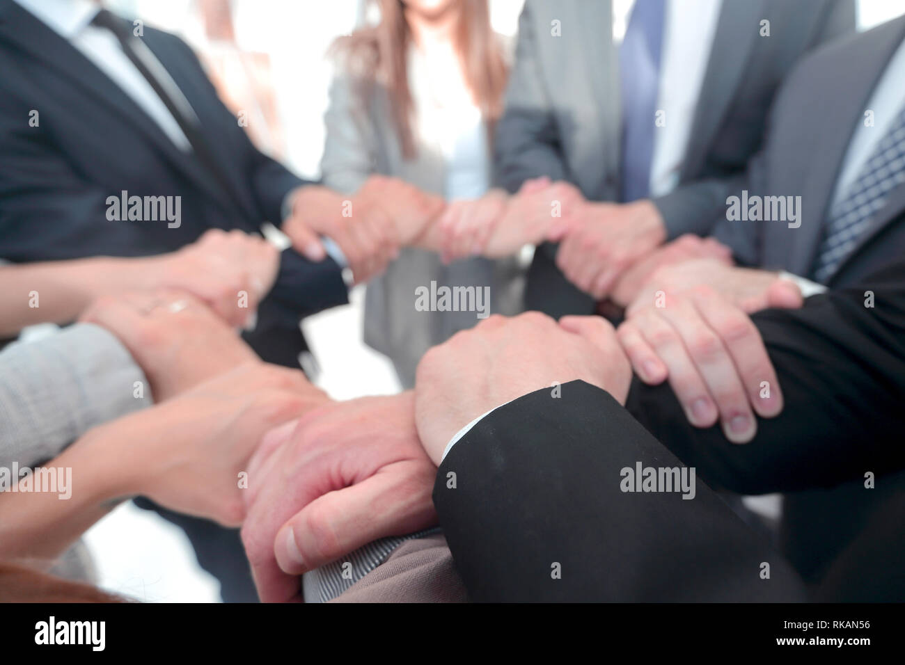 background image of business team folded their hands forming a circle ...