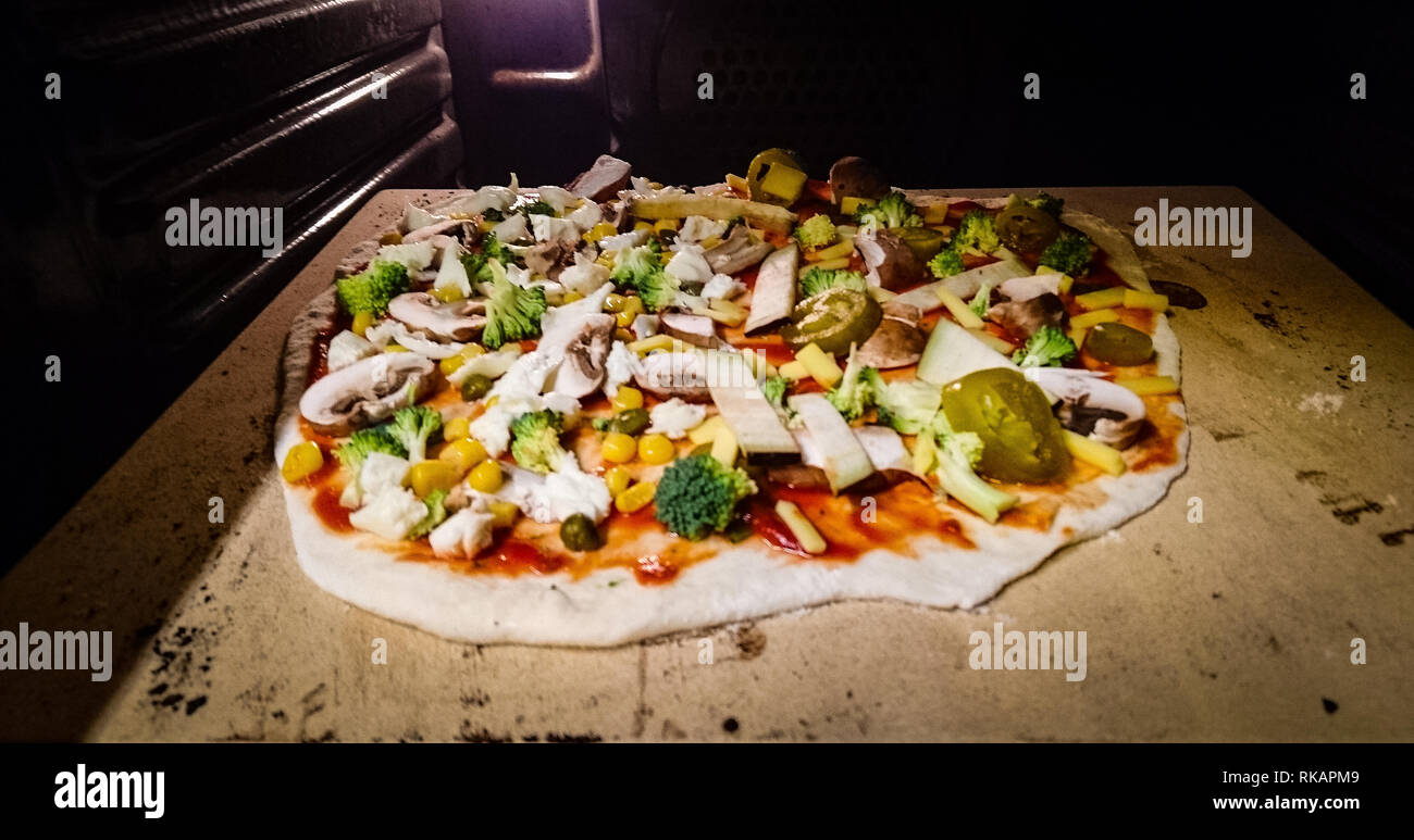 A self made pizza in the oven Stock Photo - Alamy