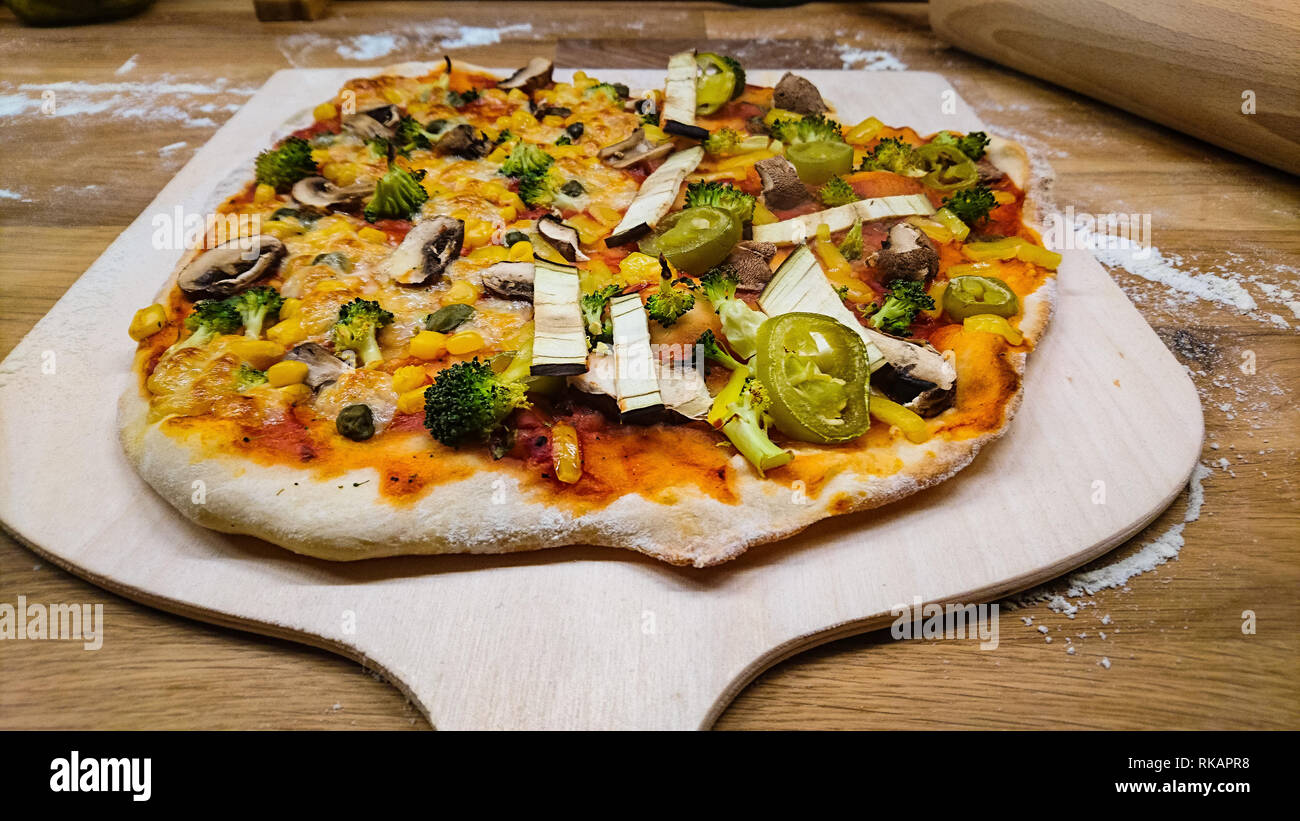 Angled view of a self made pizza on a pizza shovel Stock Photo - Alamy