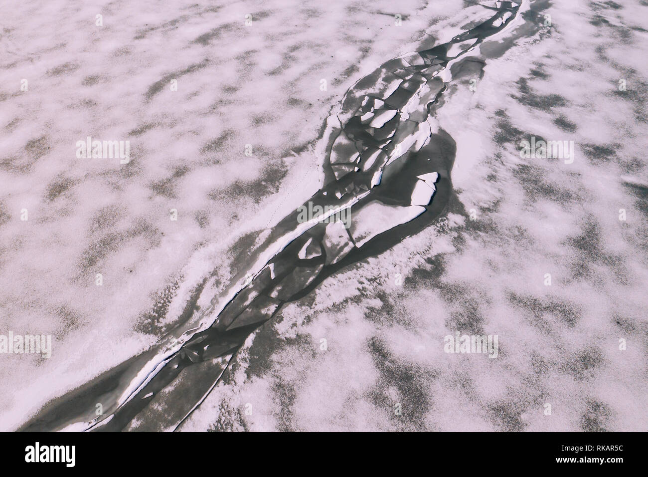 Aerial view of the winter snow covered forest and frozen lake from ...