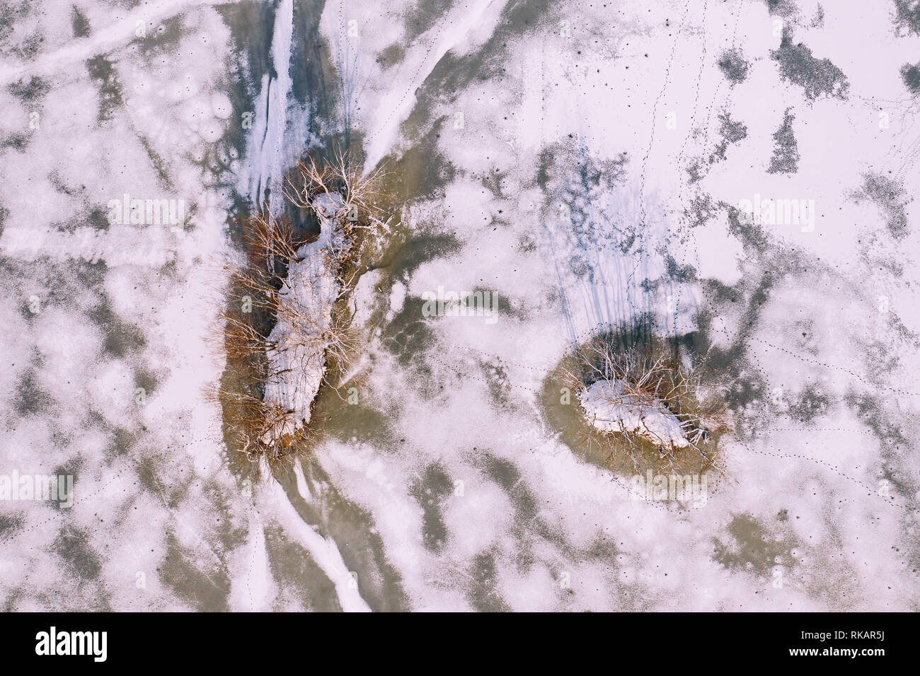 Aerial view of the winter snow covered forest and frozen lake from ...
