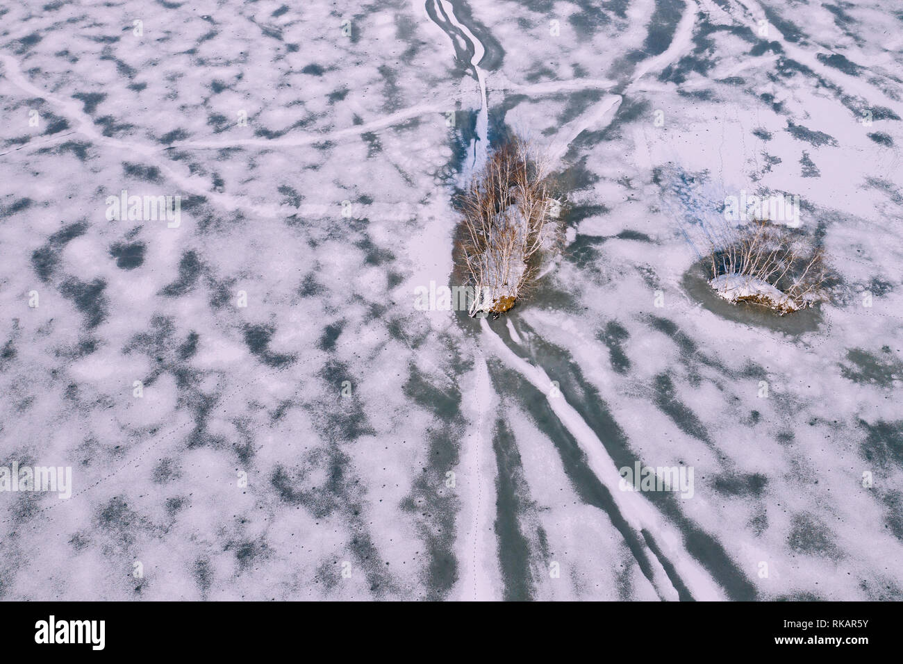 Aerial view of the winter snow covered forest and frozen lake from ...